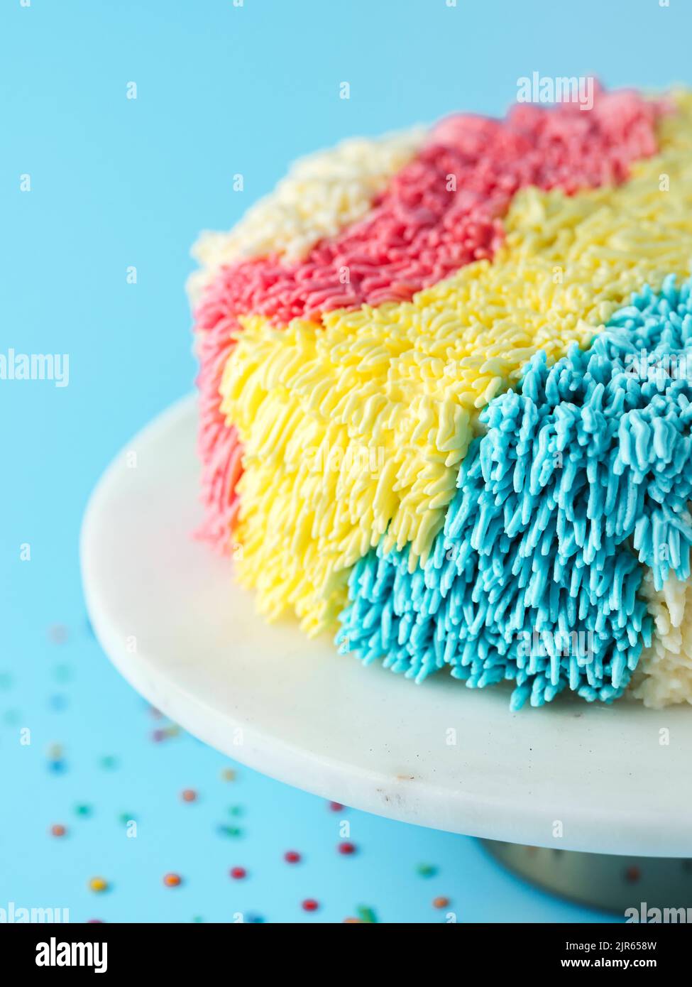 Shag cake on blue background. Funny colorful vanilla shag cake with ...