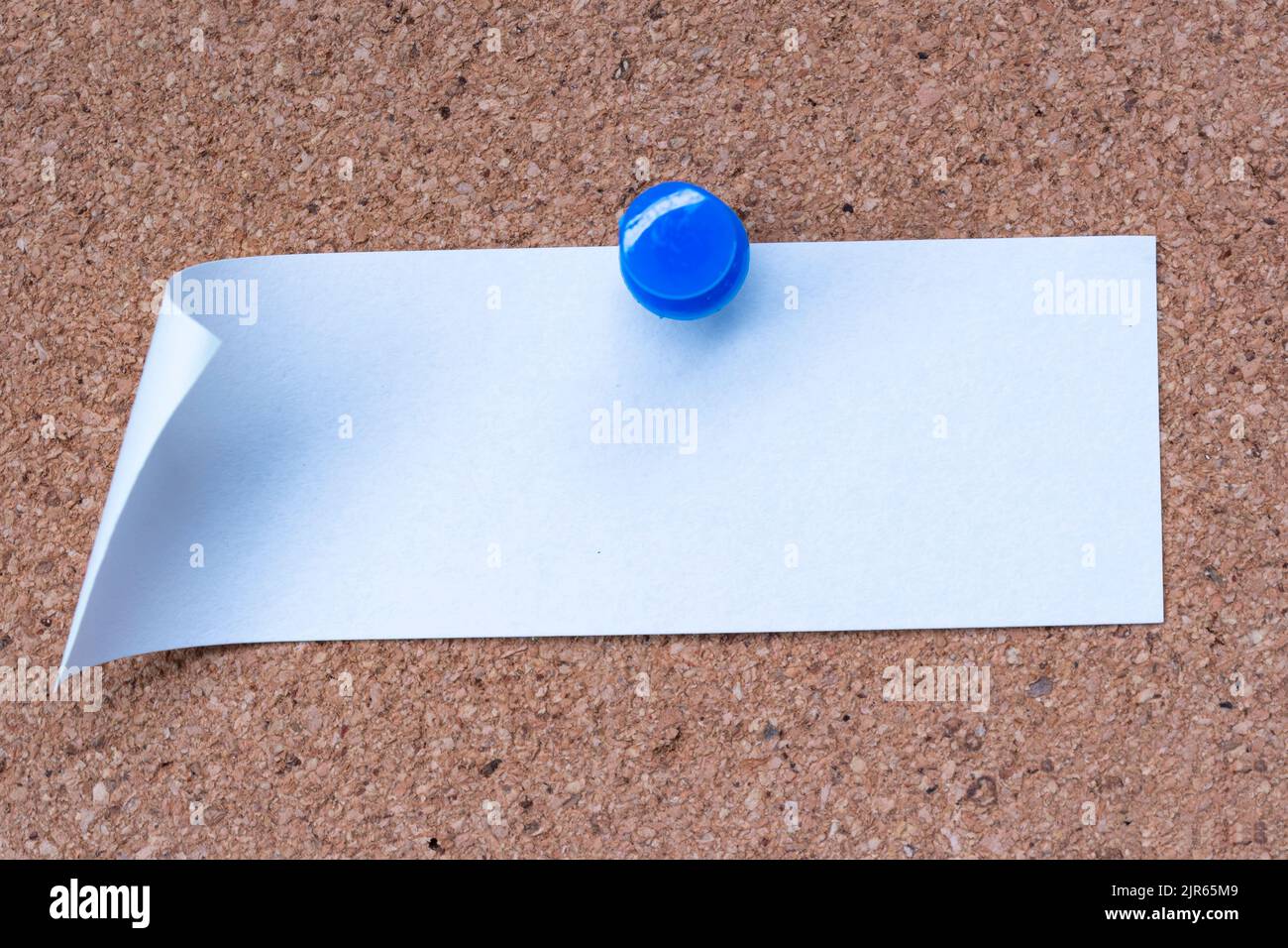 White stick note and pinned to a cork notice board. Copy space ...