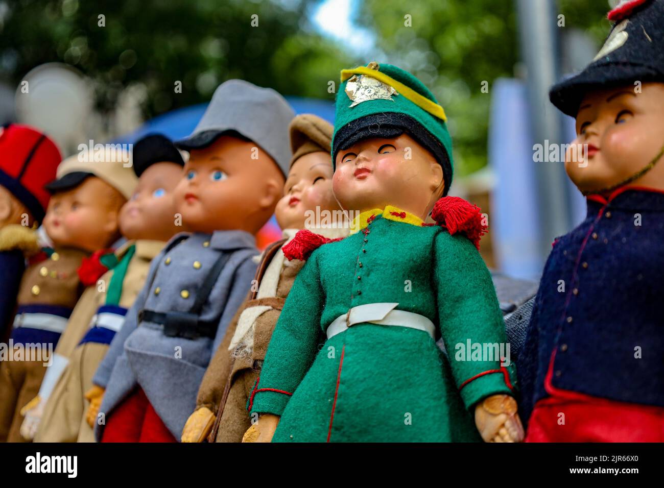 A closeup of old toys dressed in different uniforms at a flea market in ...
