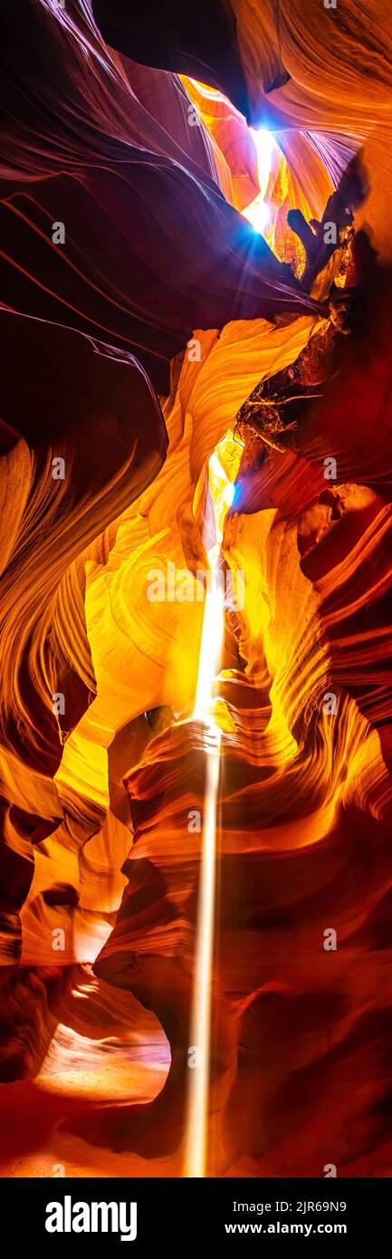 A vertical shot of a light beam in the stunning orange caves of Upper ...