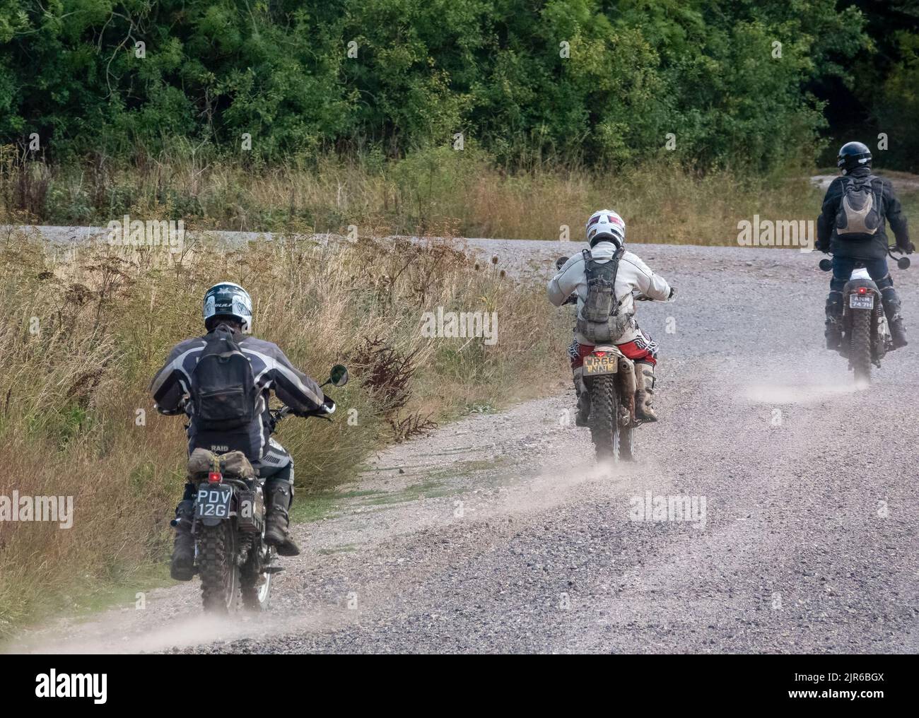 a group of three motor cyclists (bikers) riding their off-road ...