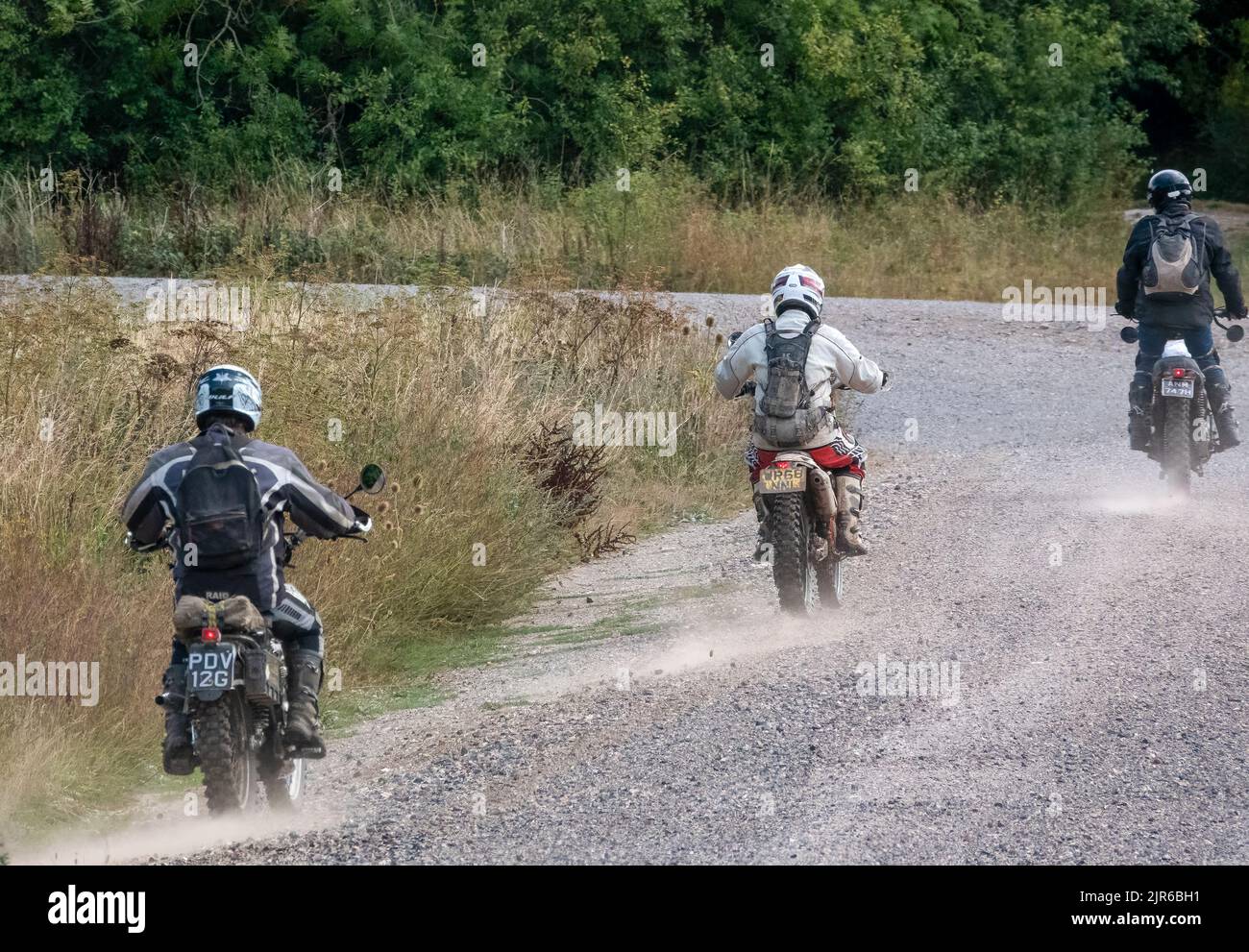 a group of three motor cyclists (bikers) riding their off-road ...