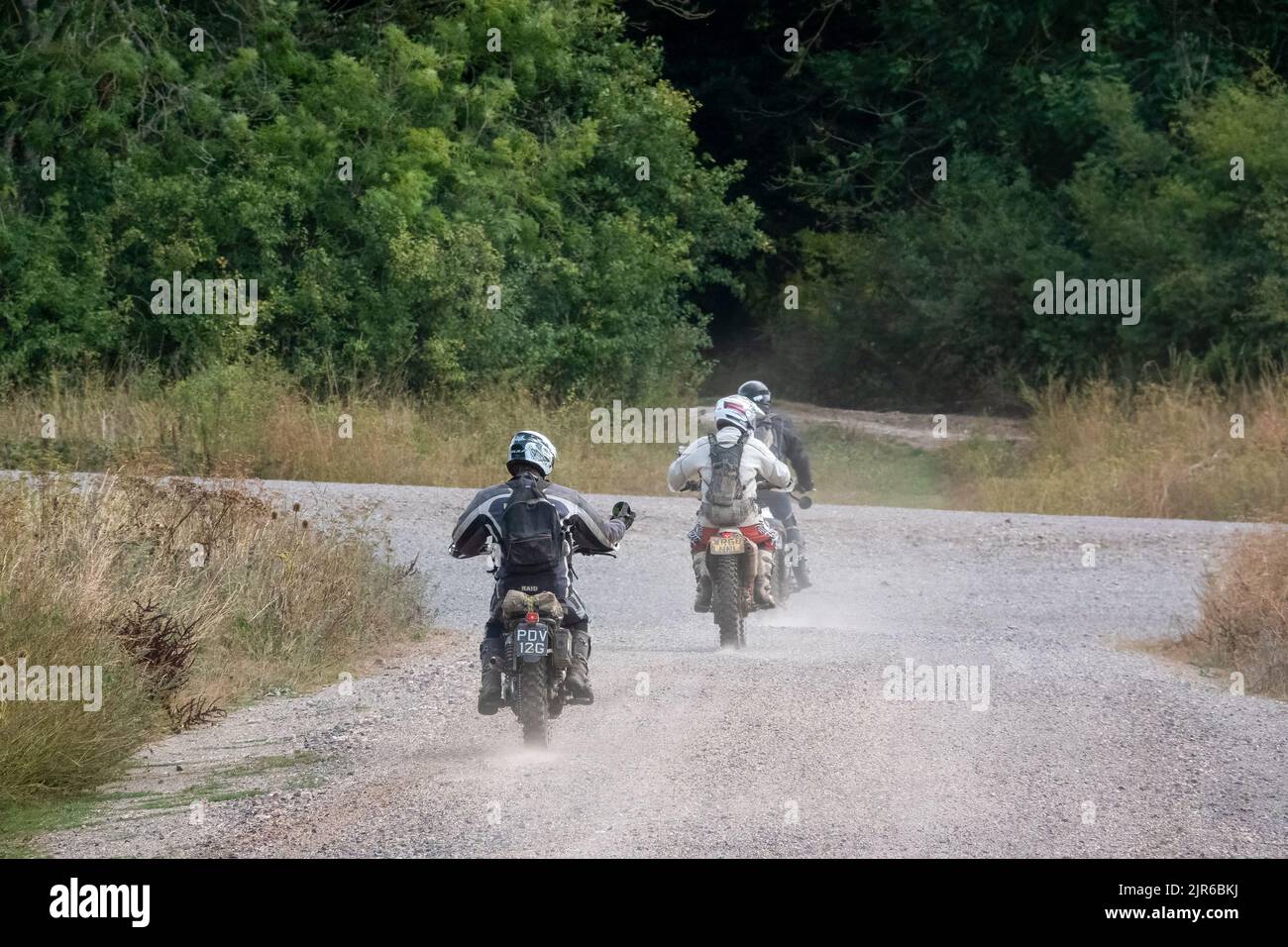 a group of three motor cyclists (bikers) riding their off-road ...