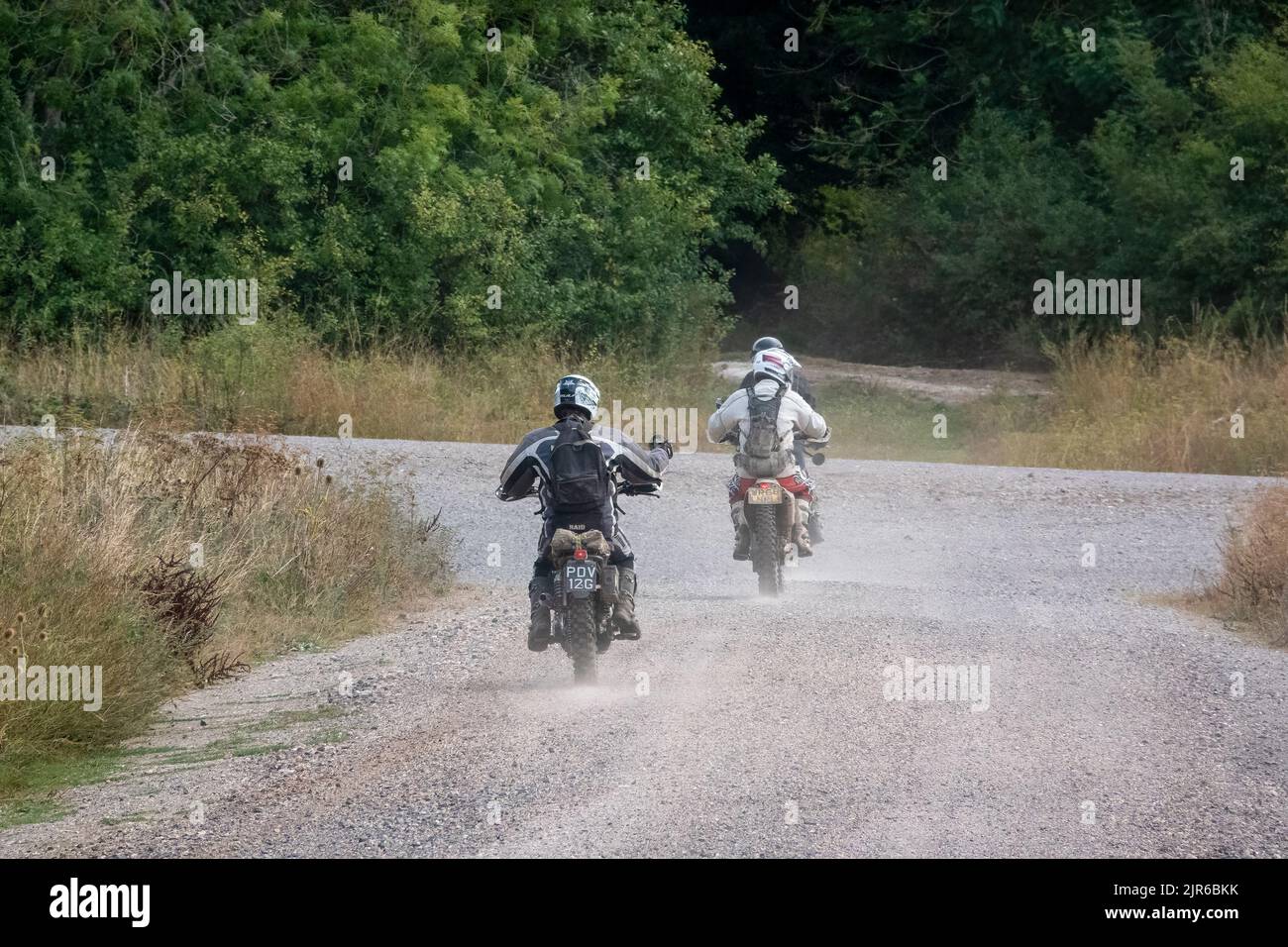 a group of three motor cyclists (bikers) riding their off-road ...