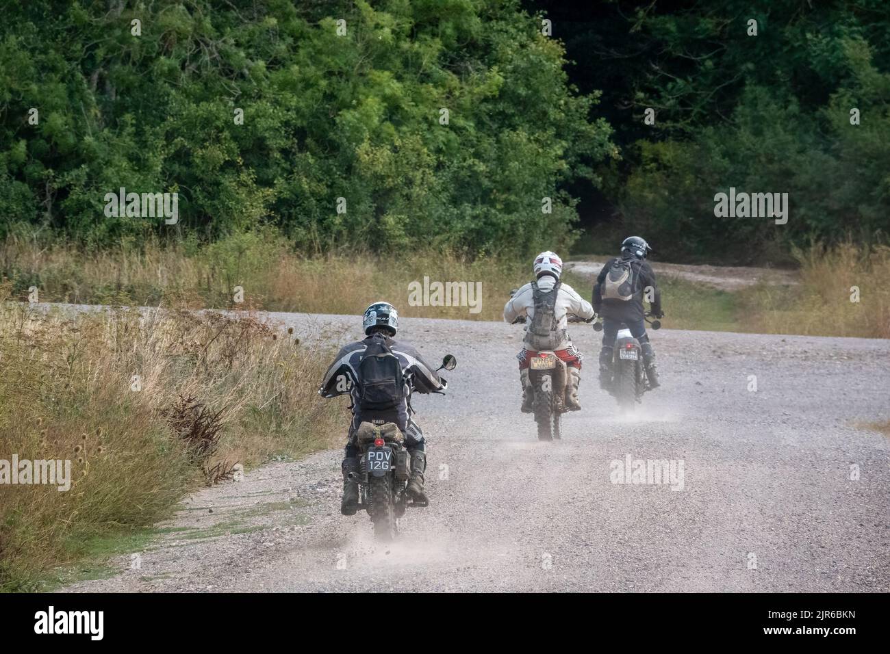 a group of three motor cyclists (bikers) riding their off-road ...