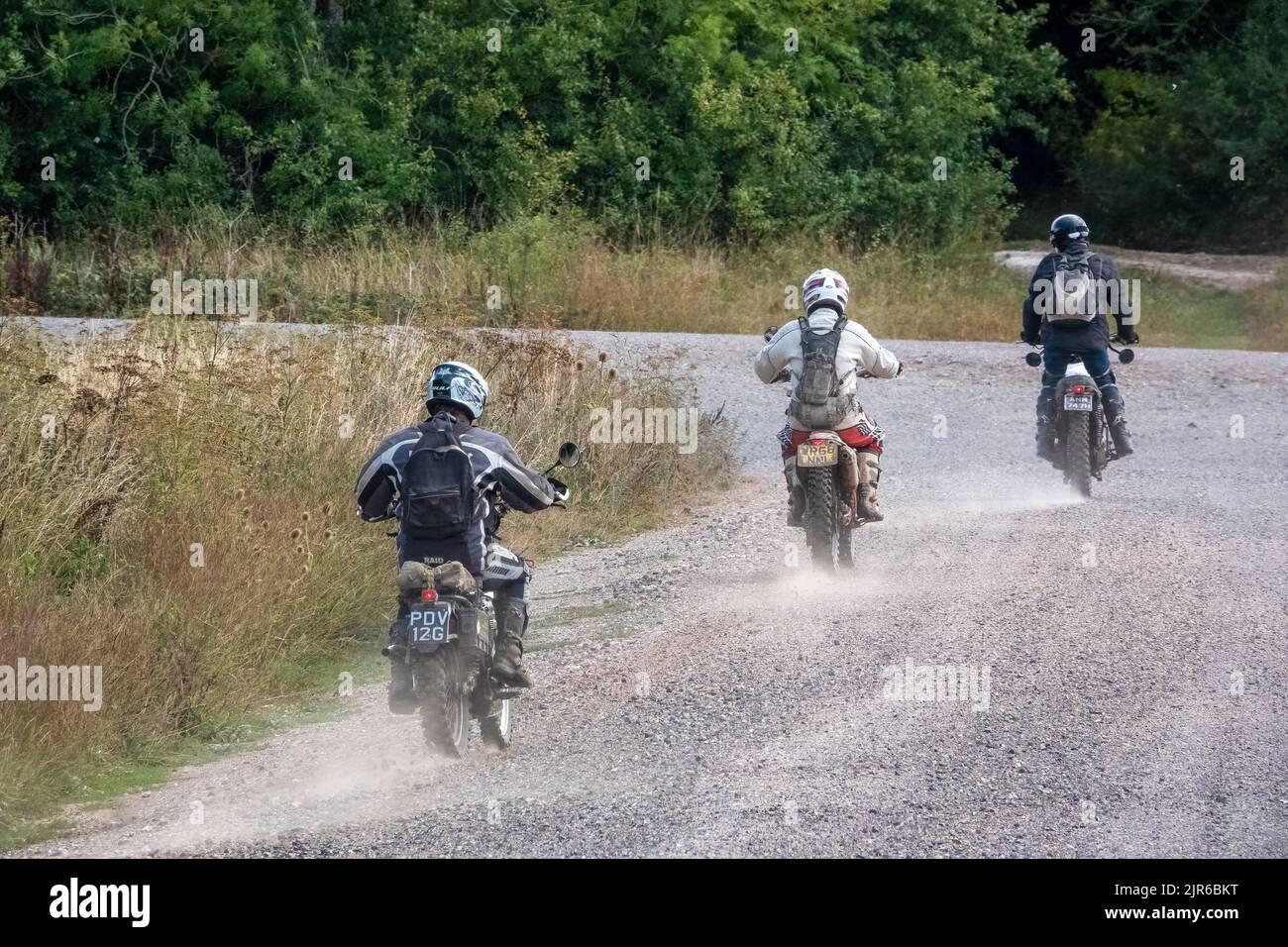 a group of three motor cyclists (bikers) riding their off-road ...