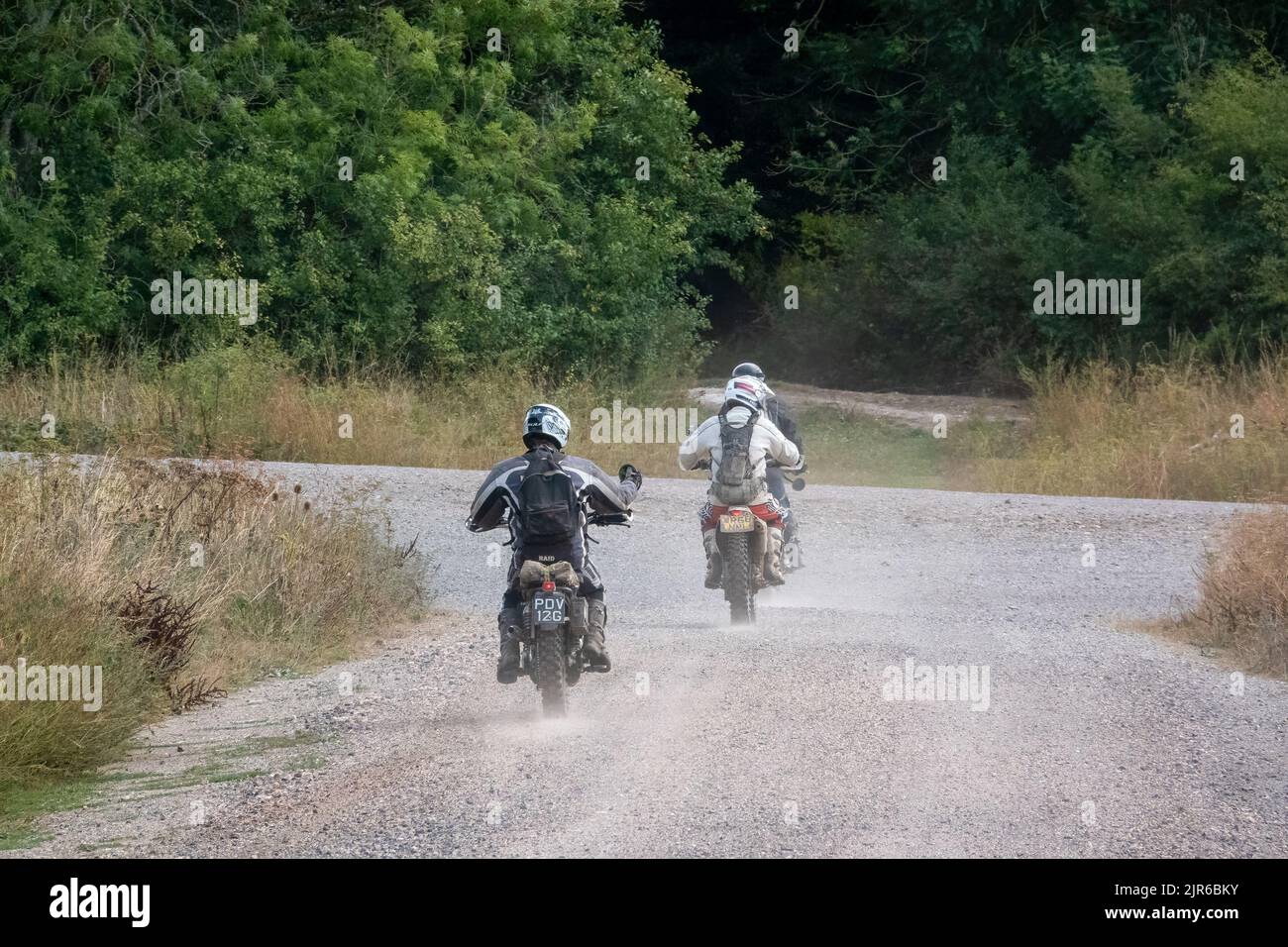 a group of three motor cyclists (bikers) riding their off-road ...