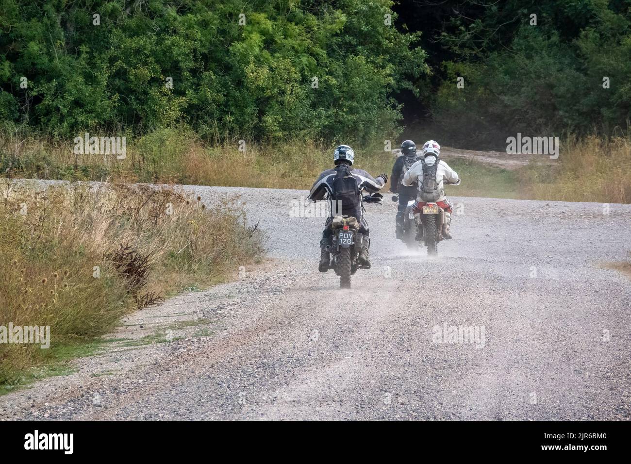 a group of three motor cyclists (bikers) riding their off-road ...