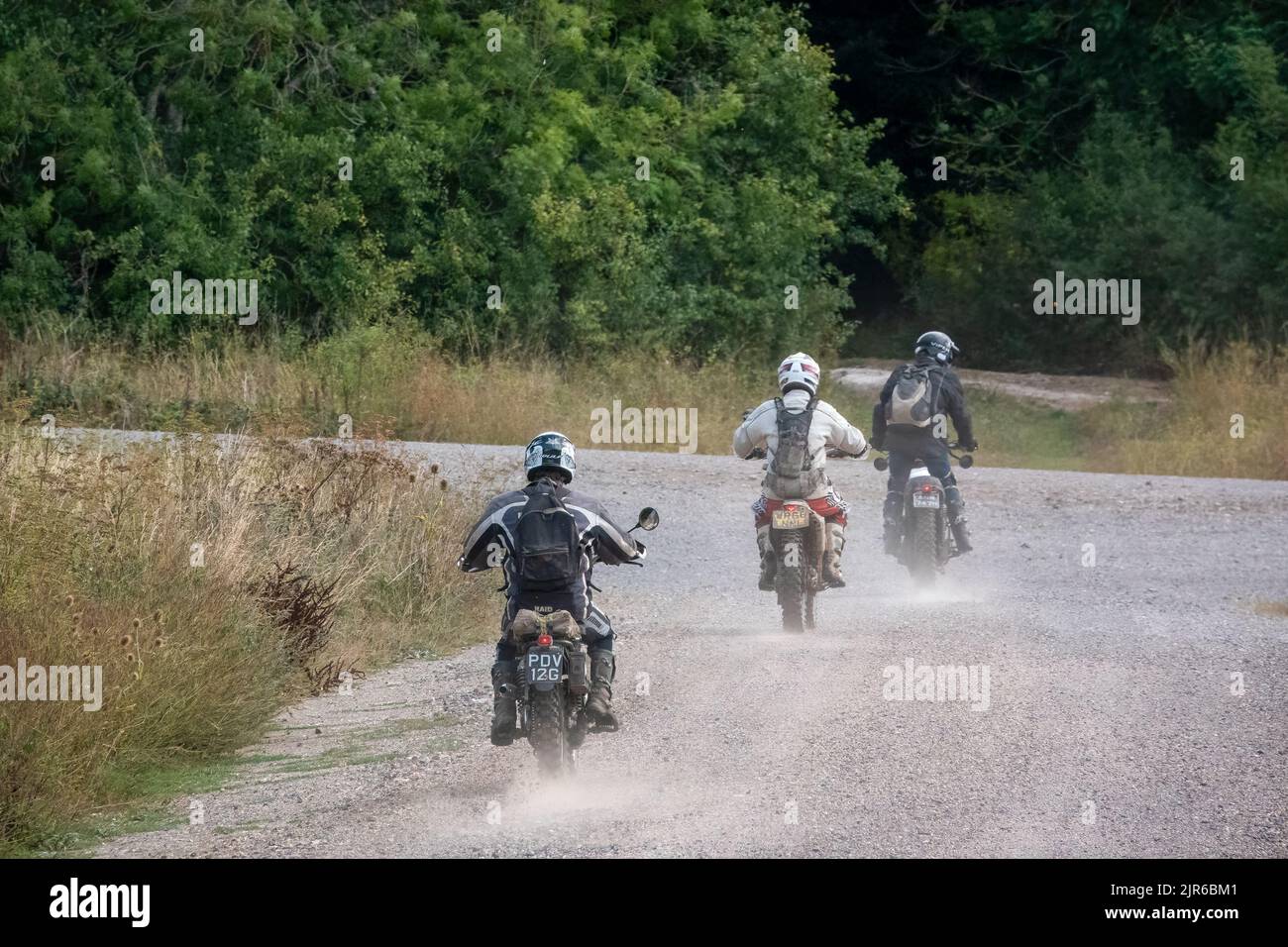 a group of three motor cyclists (bikers) riding their off-road ...