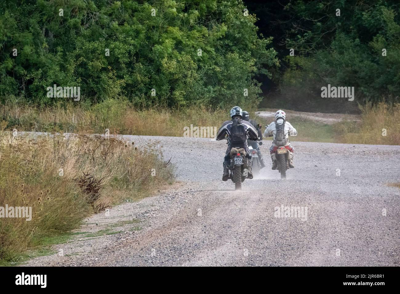 a group of three motor cyclists (bikers) riding their off-road ...