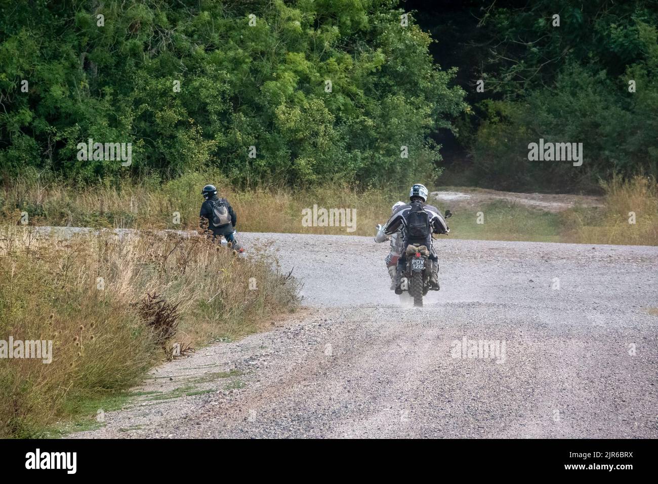a group of three motor cyclists (bikers) riding their off-road ...