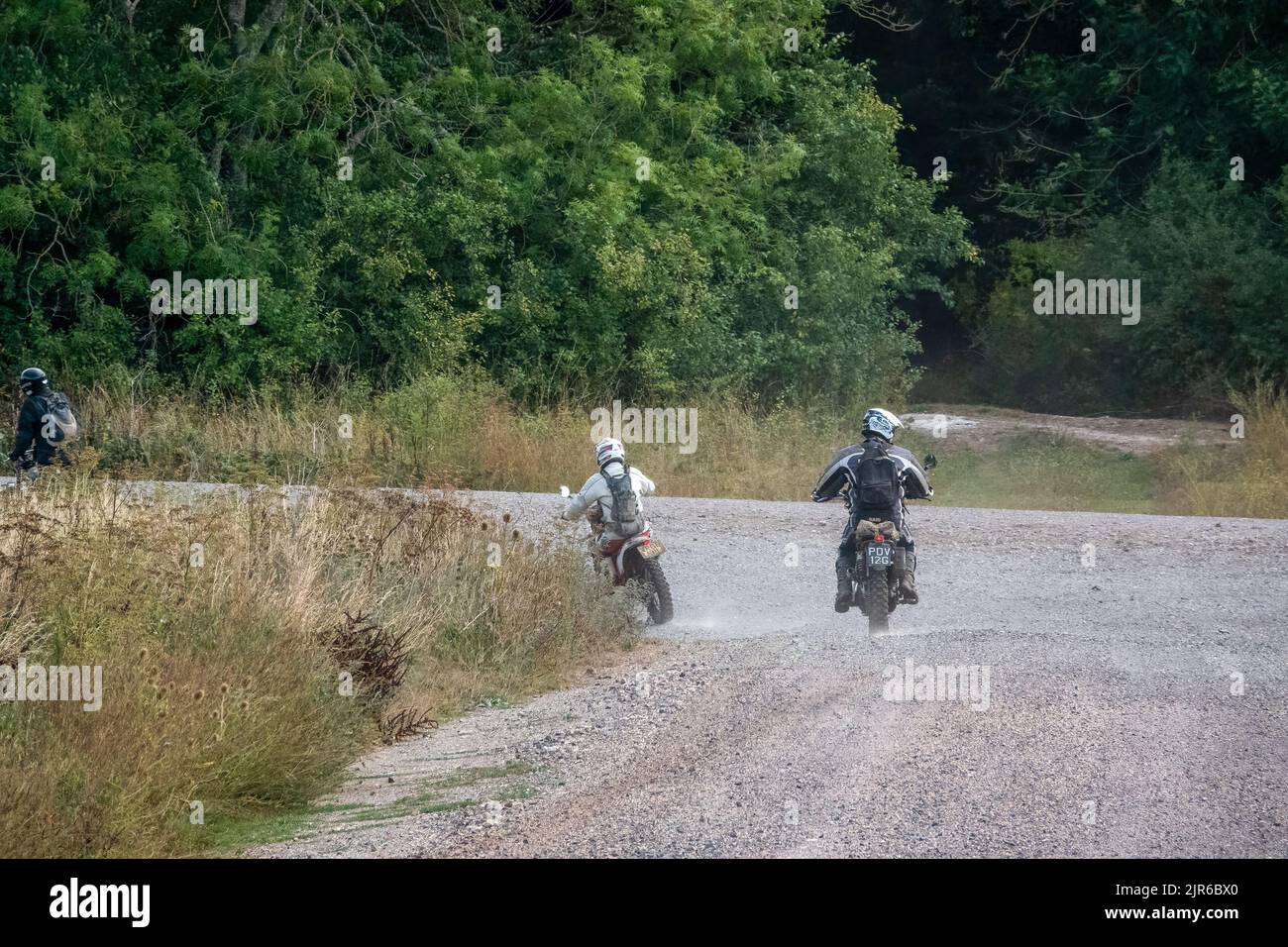 a group of three motor cyclists (bikers) riding their off-road ...