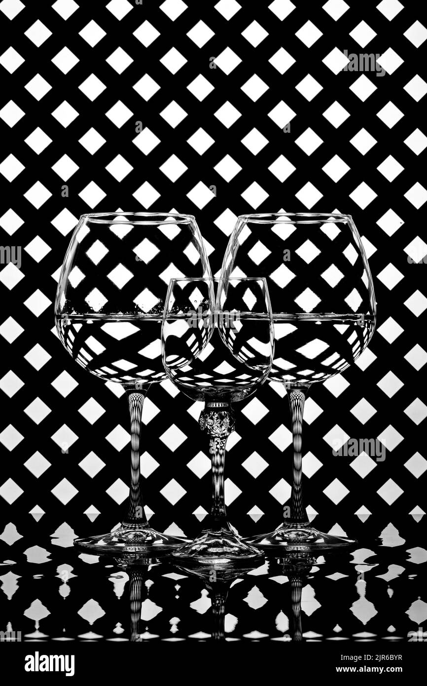 Still life with glasses with liquid on a grid background Stock Photo ...