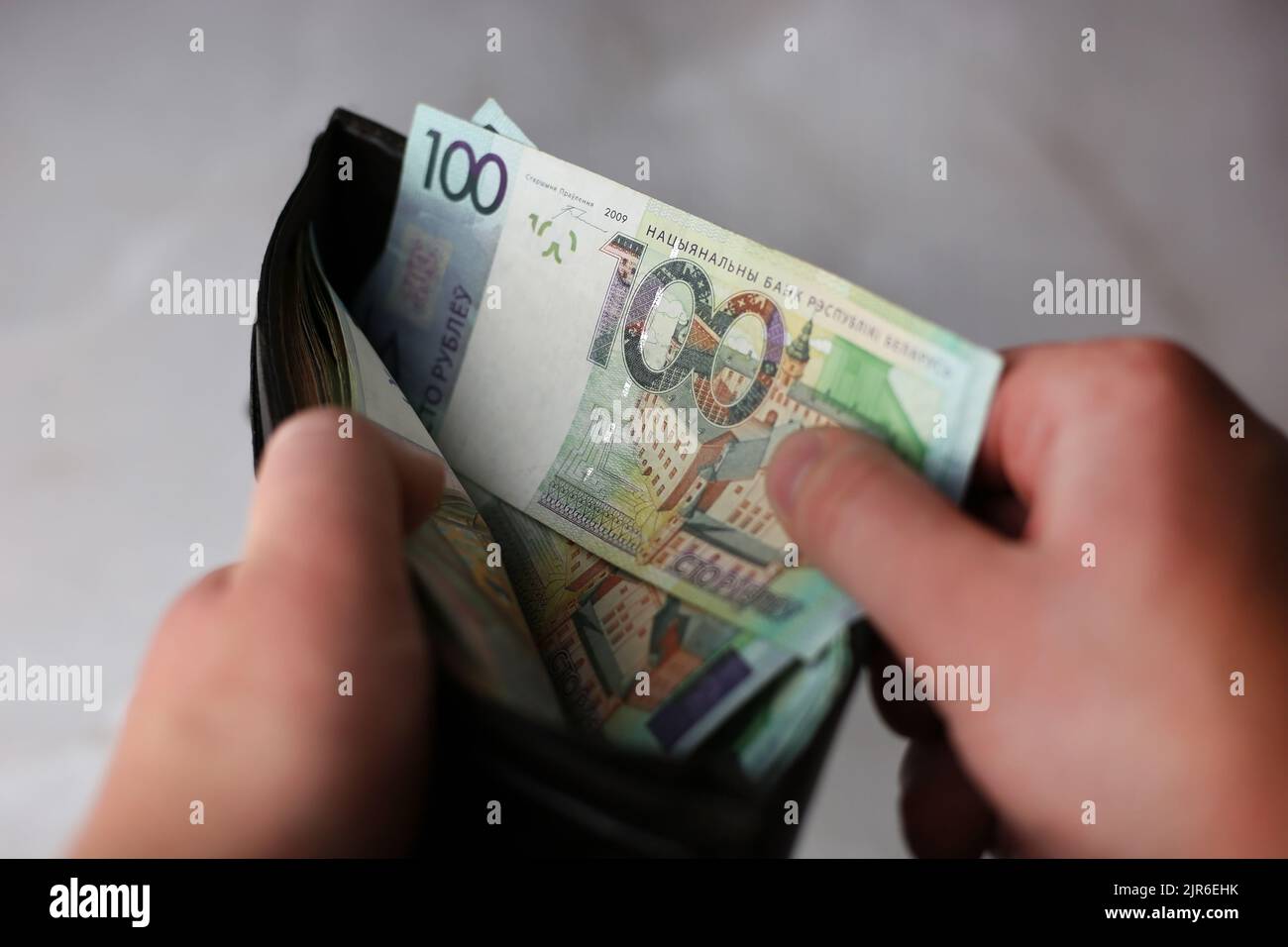 Puts in a wallet or takes out a bill of 100 Belarusian rubles Stock ...