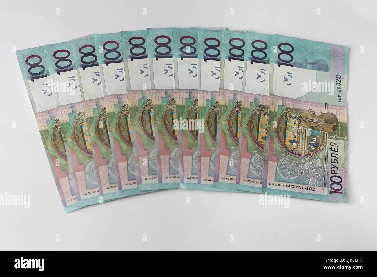 Banknotes in denominations of 100 Belarusian rubles laid out on a gray ...