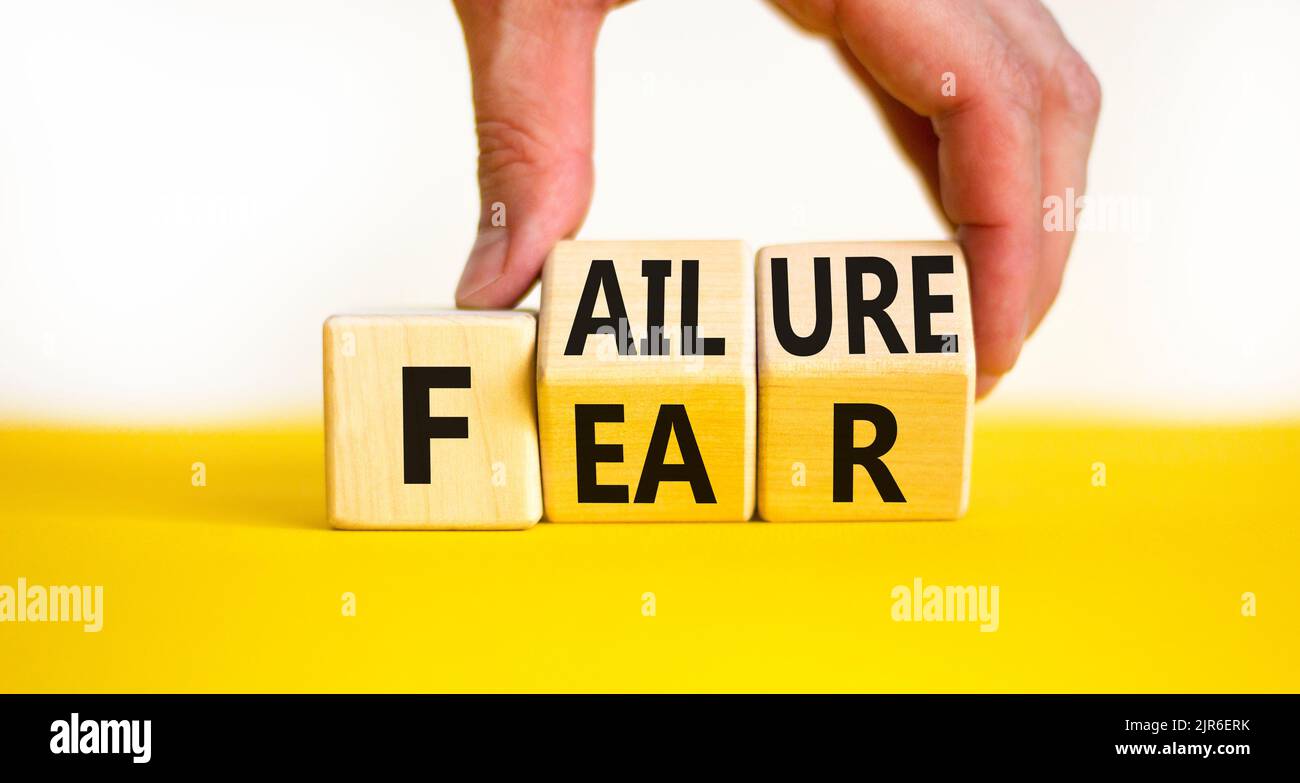 Fear of failure symbol. Businessman turns wooden cubes and changes the ...