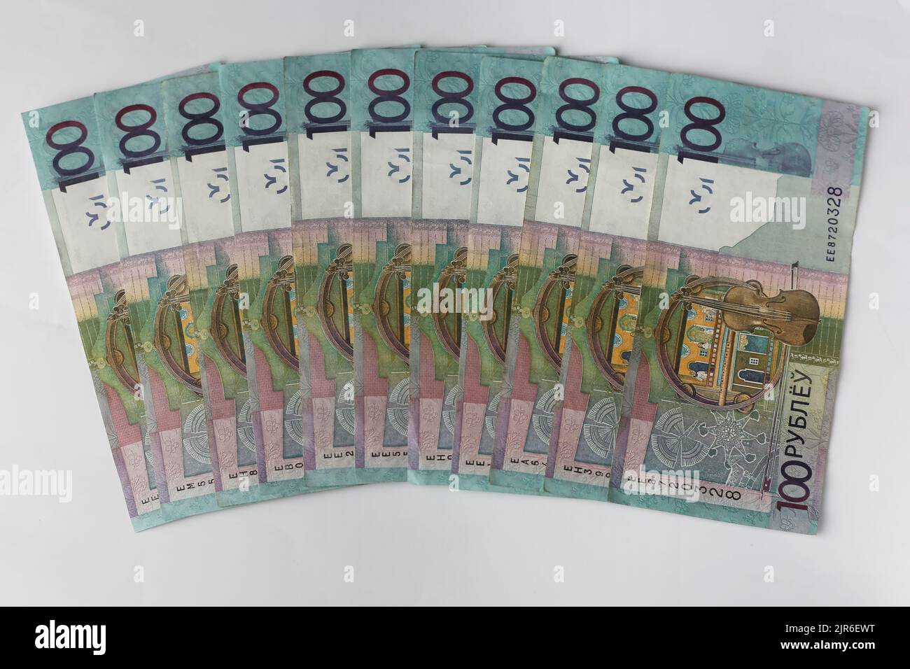 Banknotes in denominations of 100 Belarusian rubles laid out on a gray ...