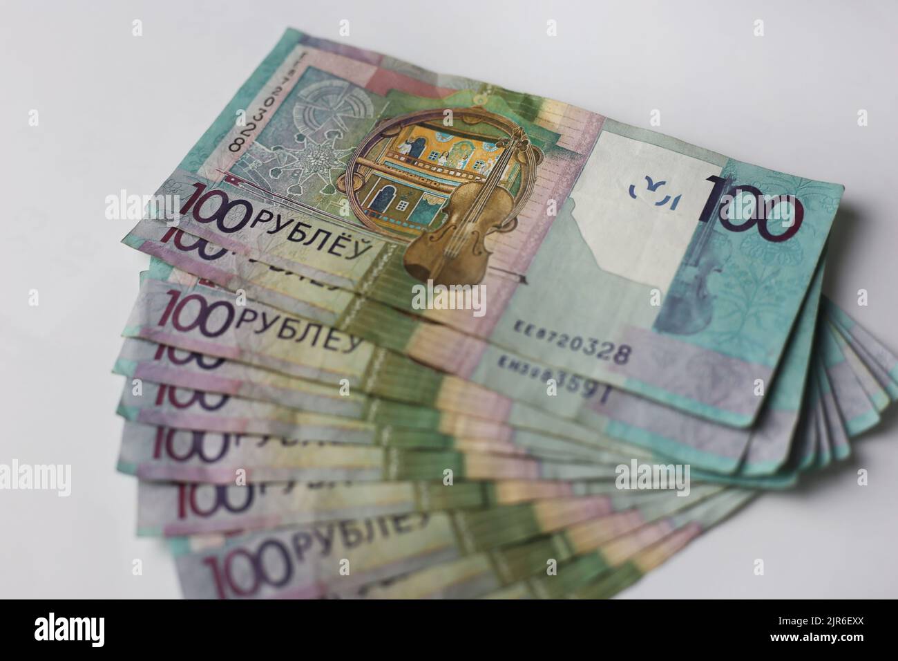 Banknotes in denominations of 100 Belarusian rubles laid out on a gray ...