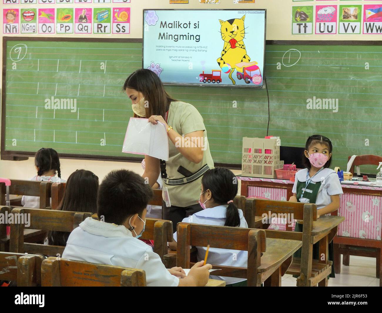 Malabon City, Philippines. 22nd Aug, 2022. A teacher seen helping her ...