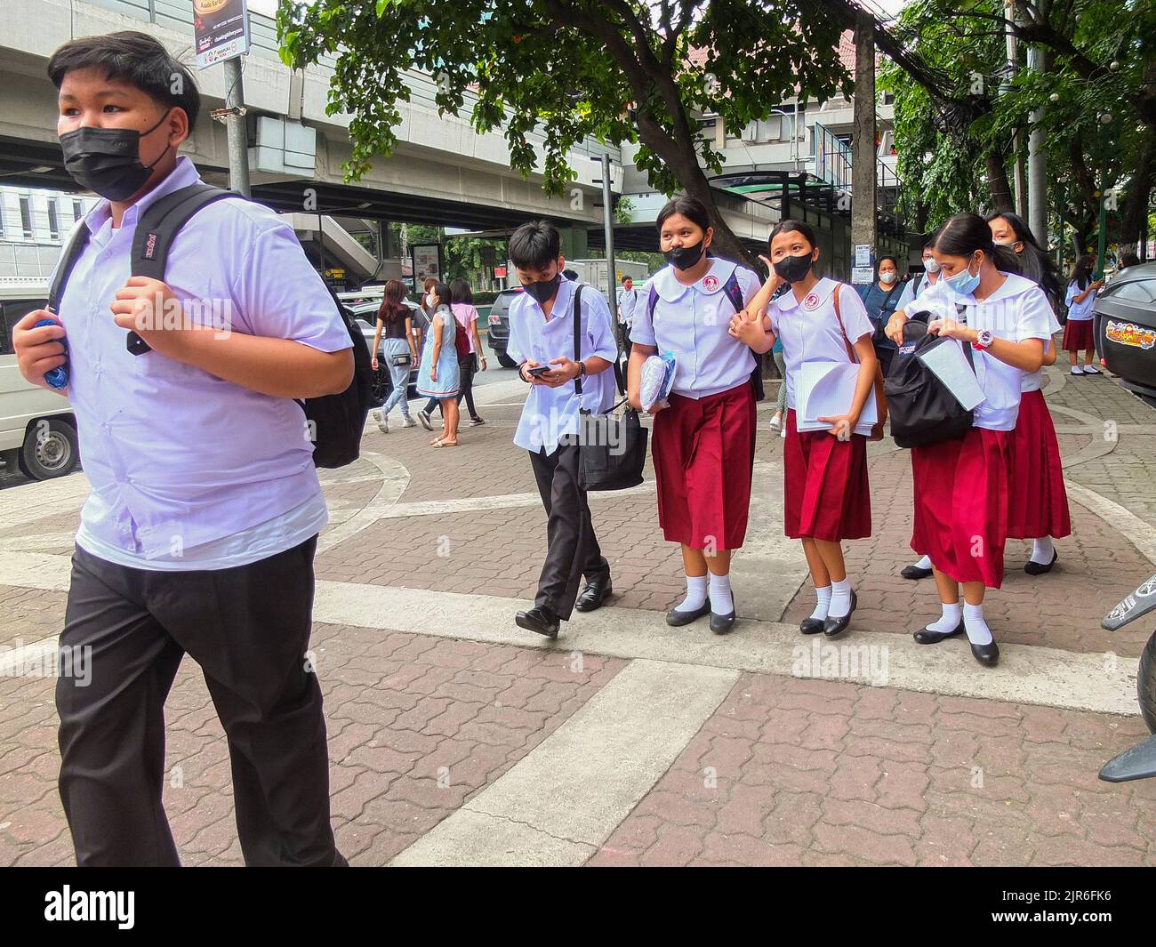 A group of students walk back home after the morning shift of classes ...