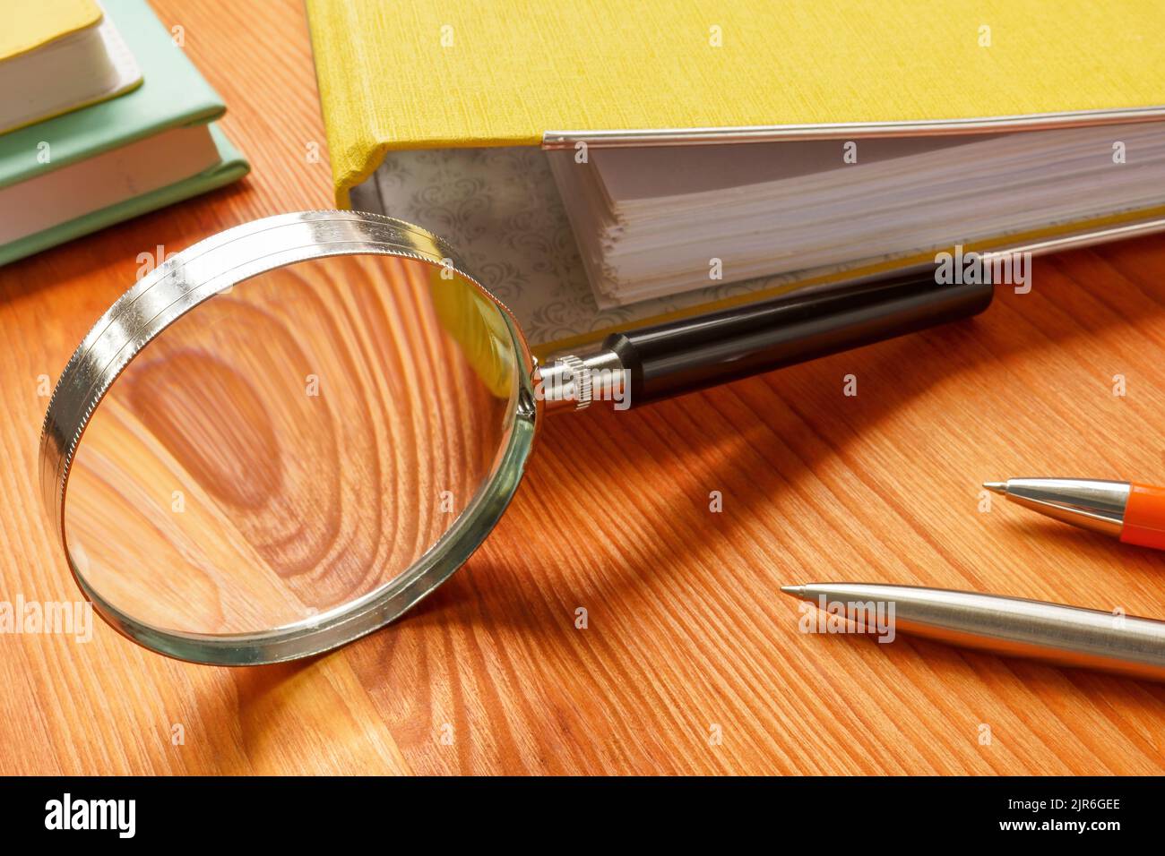 Office table with folder and magnifying glass. HR investigation concept ...