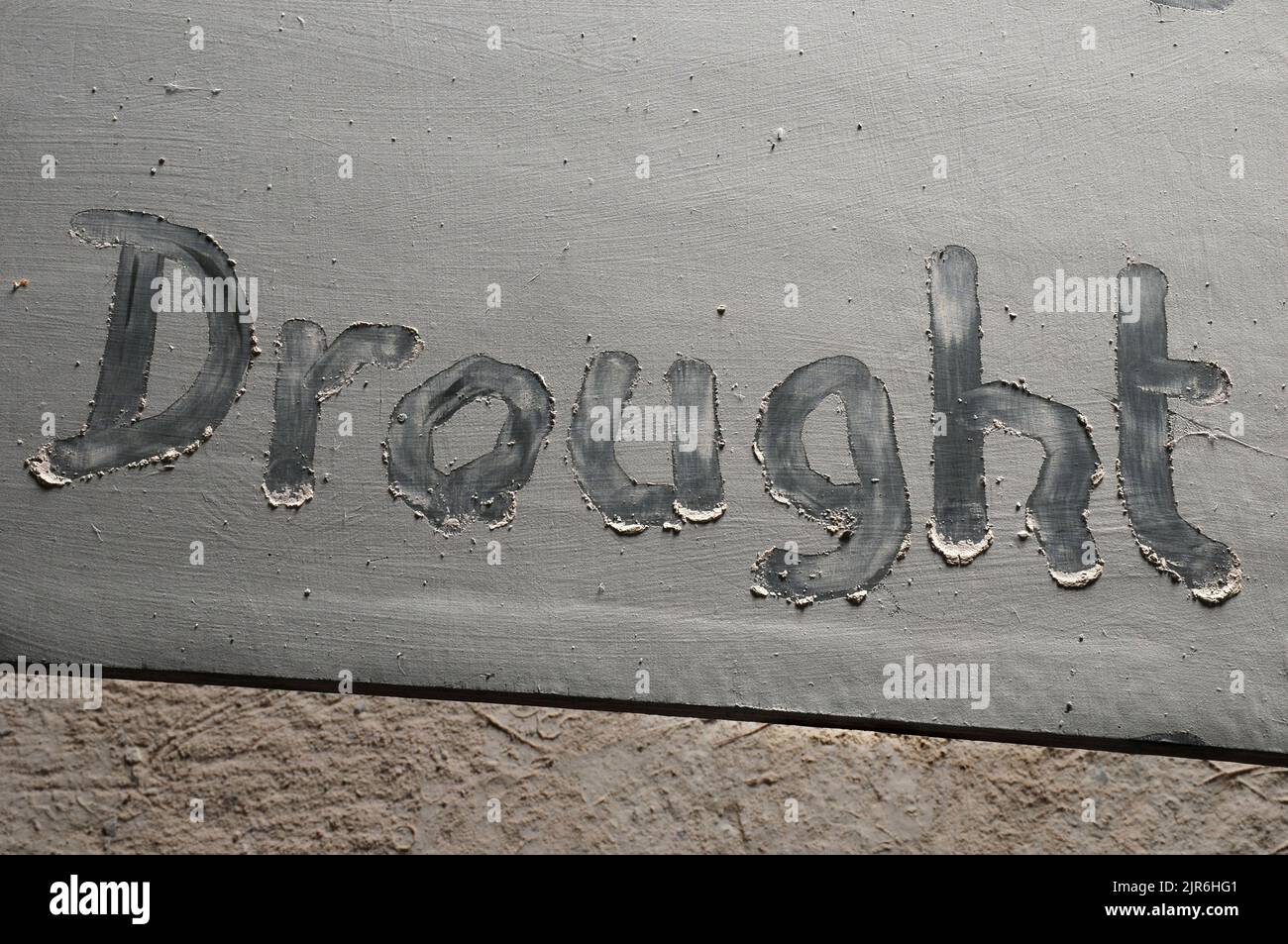 The word 'drought' scrawled by finger in dust surface Stock Photo - Alamy