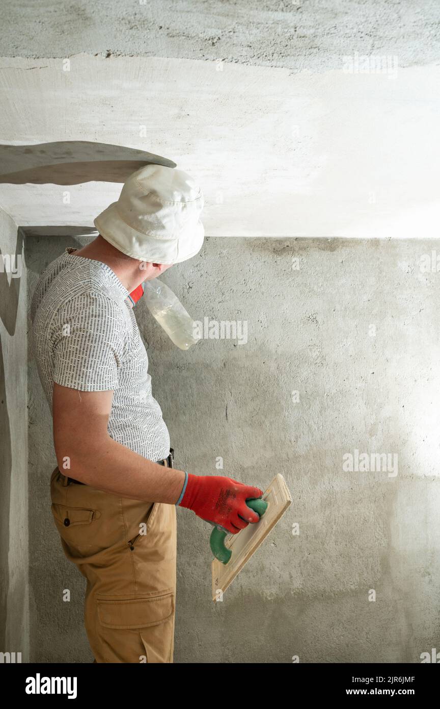 Leveling the lime plaster with a grater with a moisture-absorbing ...