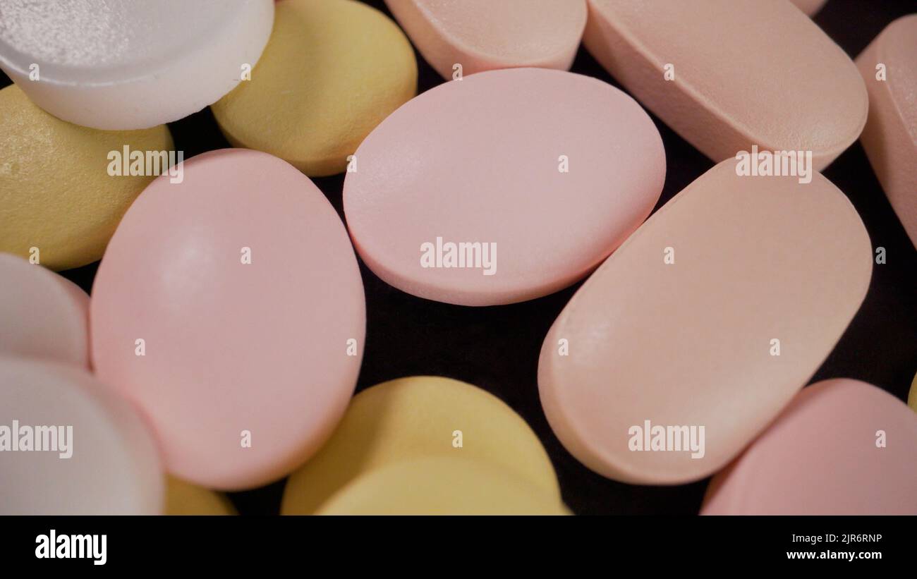 Multi-colored pills rotate close-up. Many brightly multi-colored ...