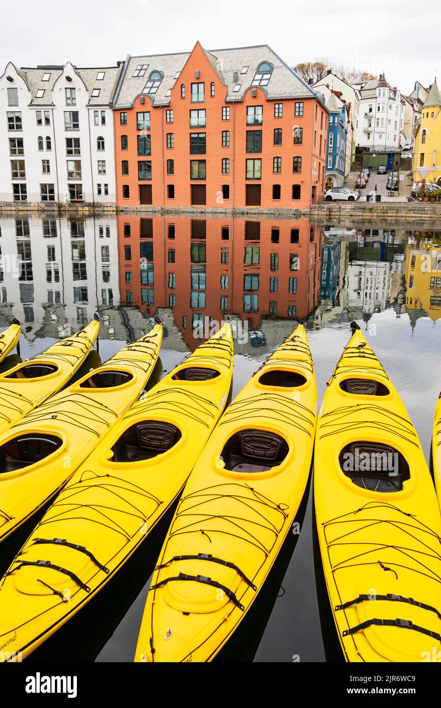 Yellow canoe kayaks pointing towards colourful waterfront houses with ...