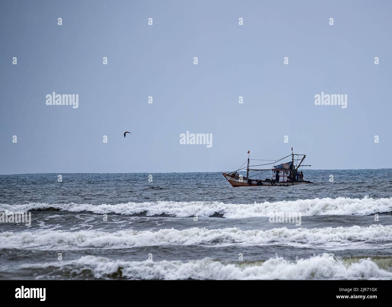 A fishing boat in sea on a hot cloudless day Stock Photo - Alamy