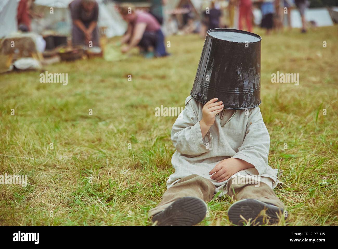 The boy fooling around puts a bucket on his head Stock Photo - Alamy