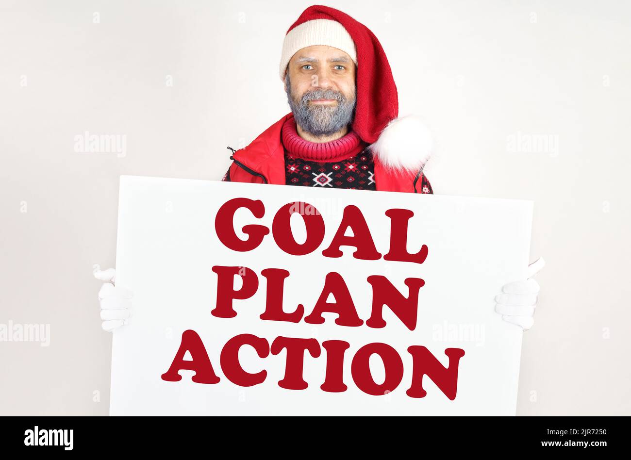 Concept of christmas and new year. Santa is holding a white sign with ...