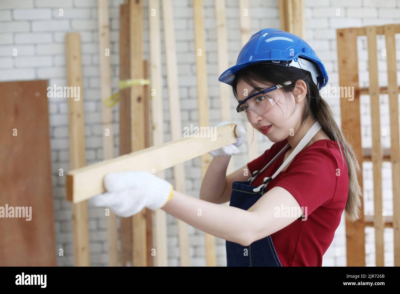 Side view portrait of modern female carpenter measuring wooden part ...