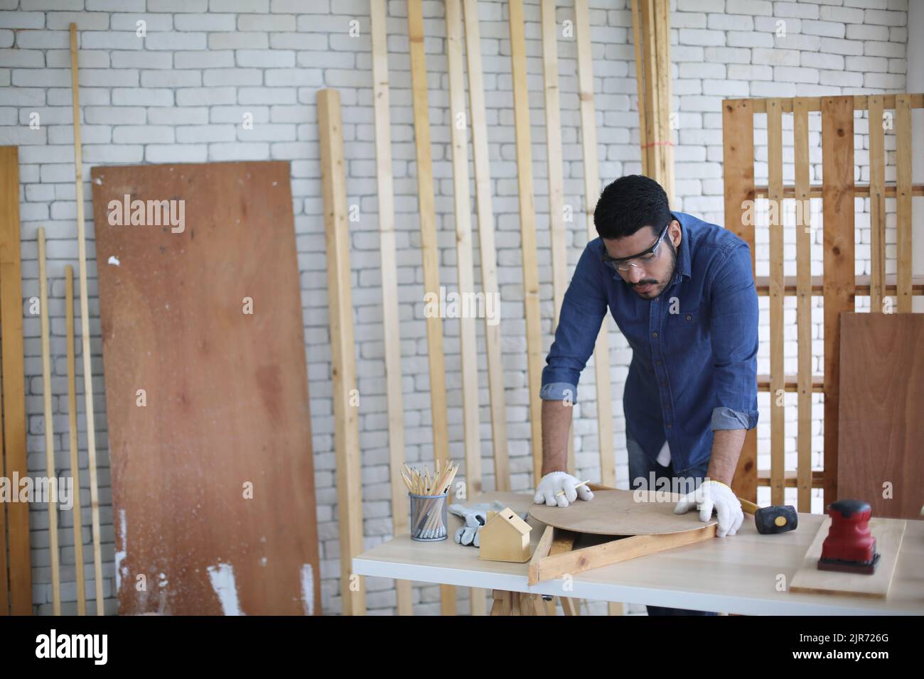 Carpenter grinding joinery product with carvings, finishing woodwork at ...