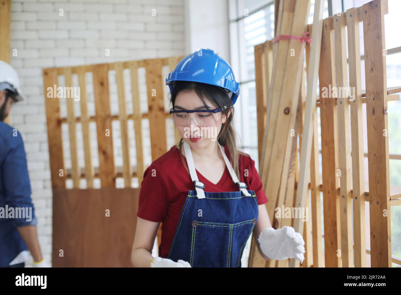 Side view portrait of modern female carpenter measuring wooden part ...