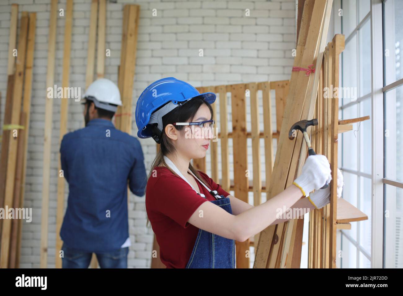 Side view portrait of modern female carpenter measuring wooden part ...