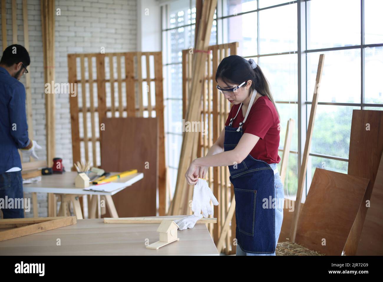 Side view portrait of modern female carpenter measuring wooden part ...