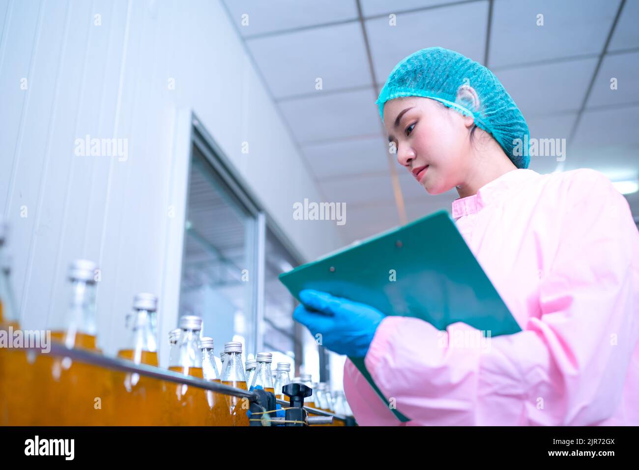 Engineer working at Fruit juice Bottle Automated conveyor belt production system. Business and ...