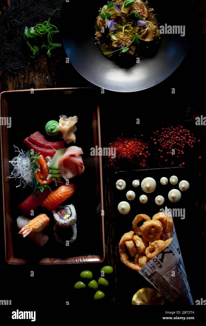 Fusion restaurant table with plates variety on black wood background ...