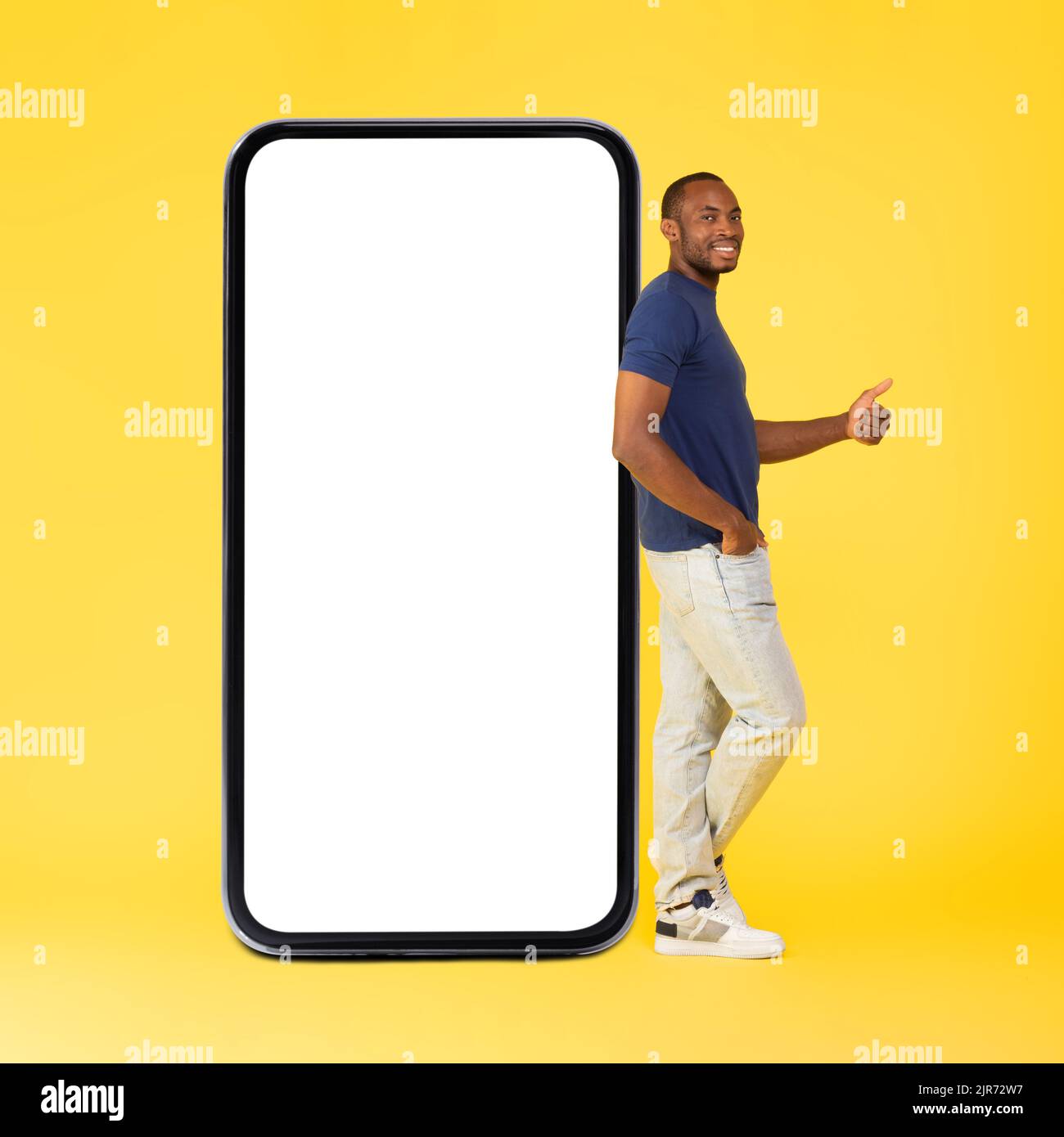 African Guy Leaning On Smartphone Gesturing Thumbs Up, Yellow ... African Guy Leaning On Smartphone Gesturing Thumbs Up, Yellow ...