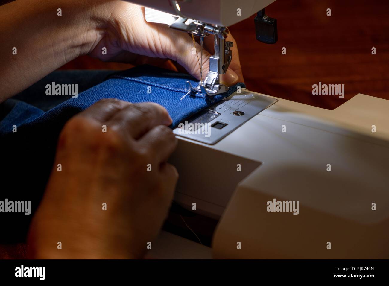 Female hands of a master tailor working with denim blue weave Stock ...