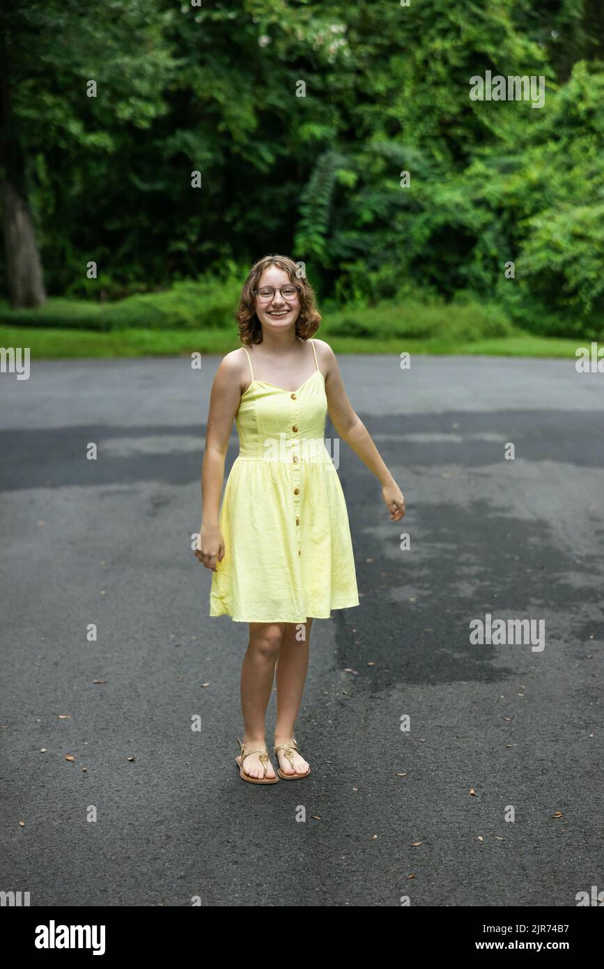 Tween almost teenage girl with braces and wearing a yellow sundress ...
