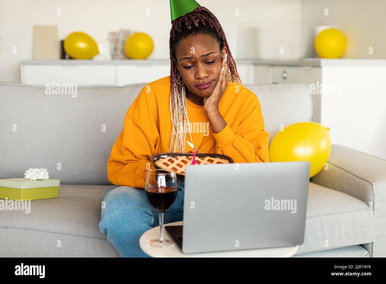Sad single african american woman in party hat celebrating birthday ...
