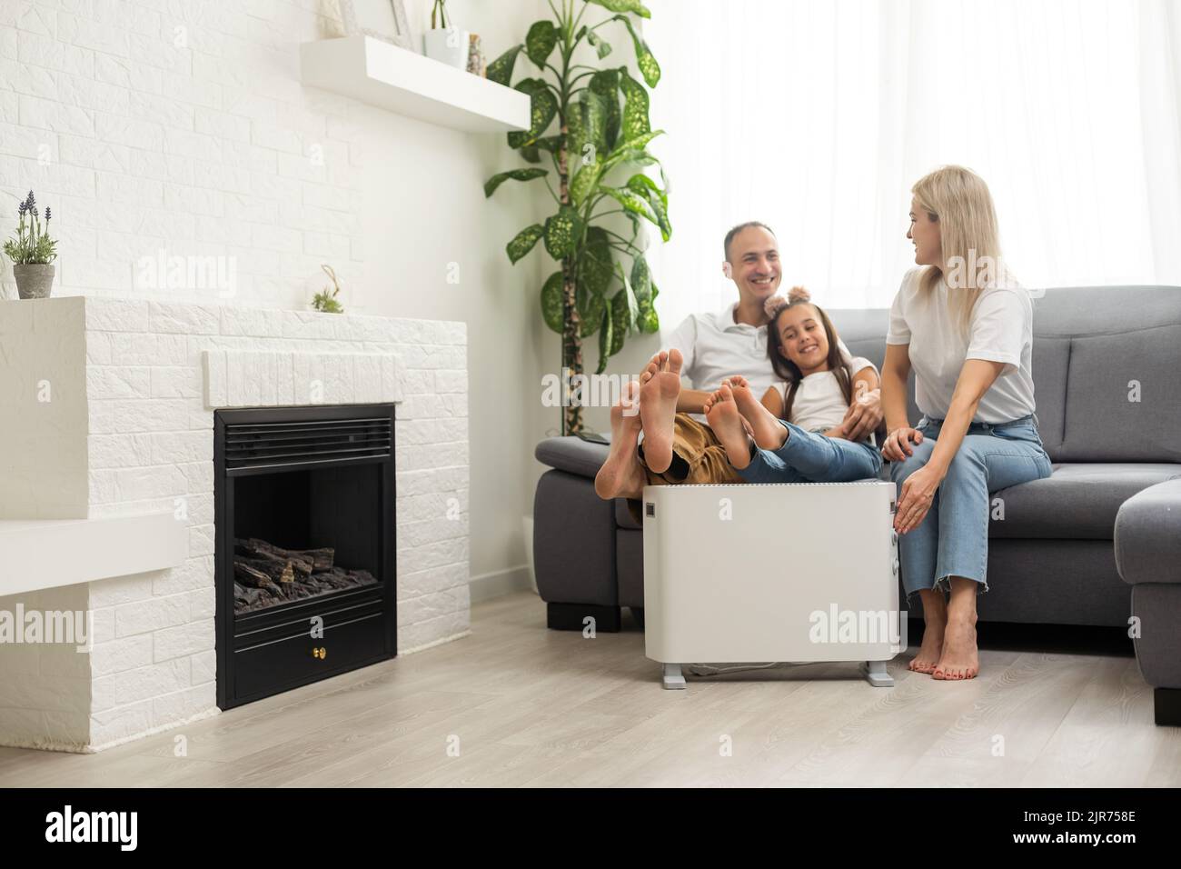 Family warming up near home heater at winter cold time. The symbolic ...