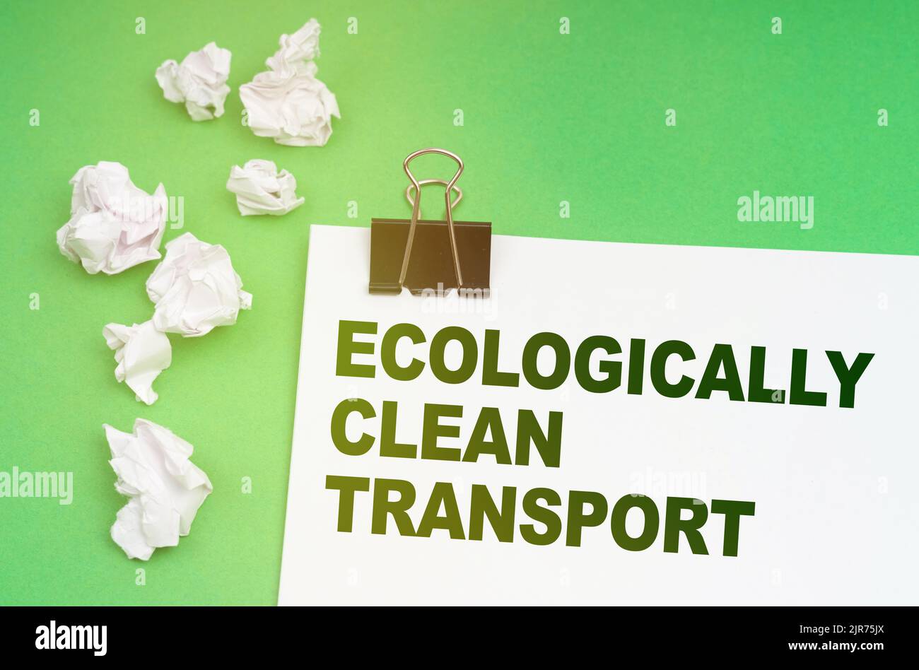 Ecology concept. On a green background, crumpled paper and a sheet with ...