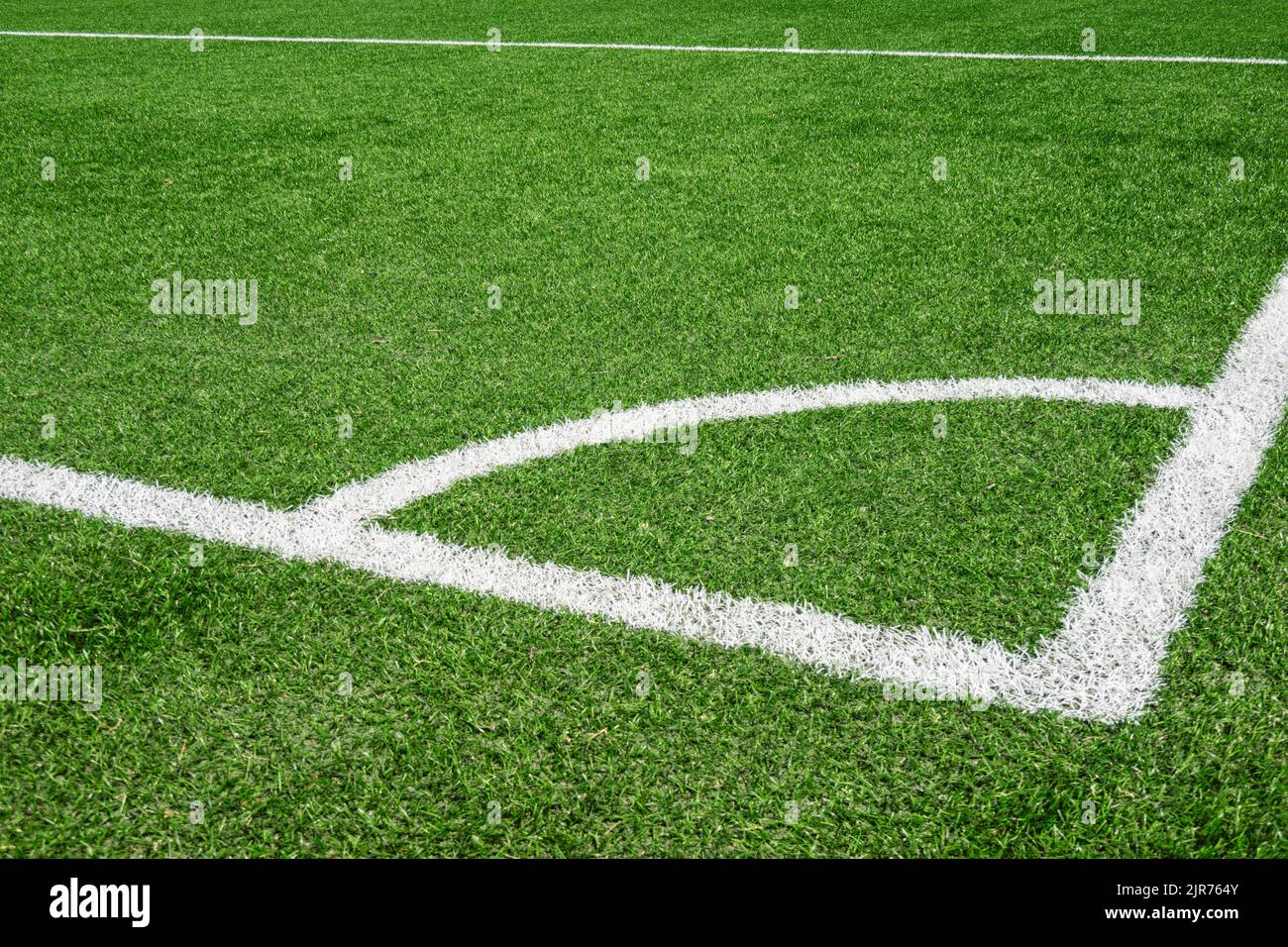 Green synthetic artificial grass soccer sports field with white corner ...