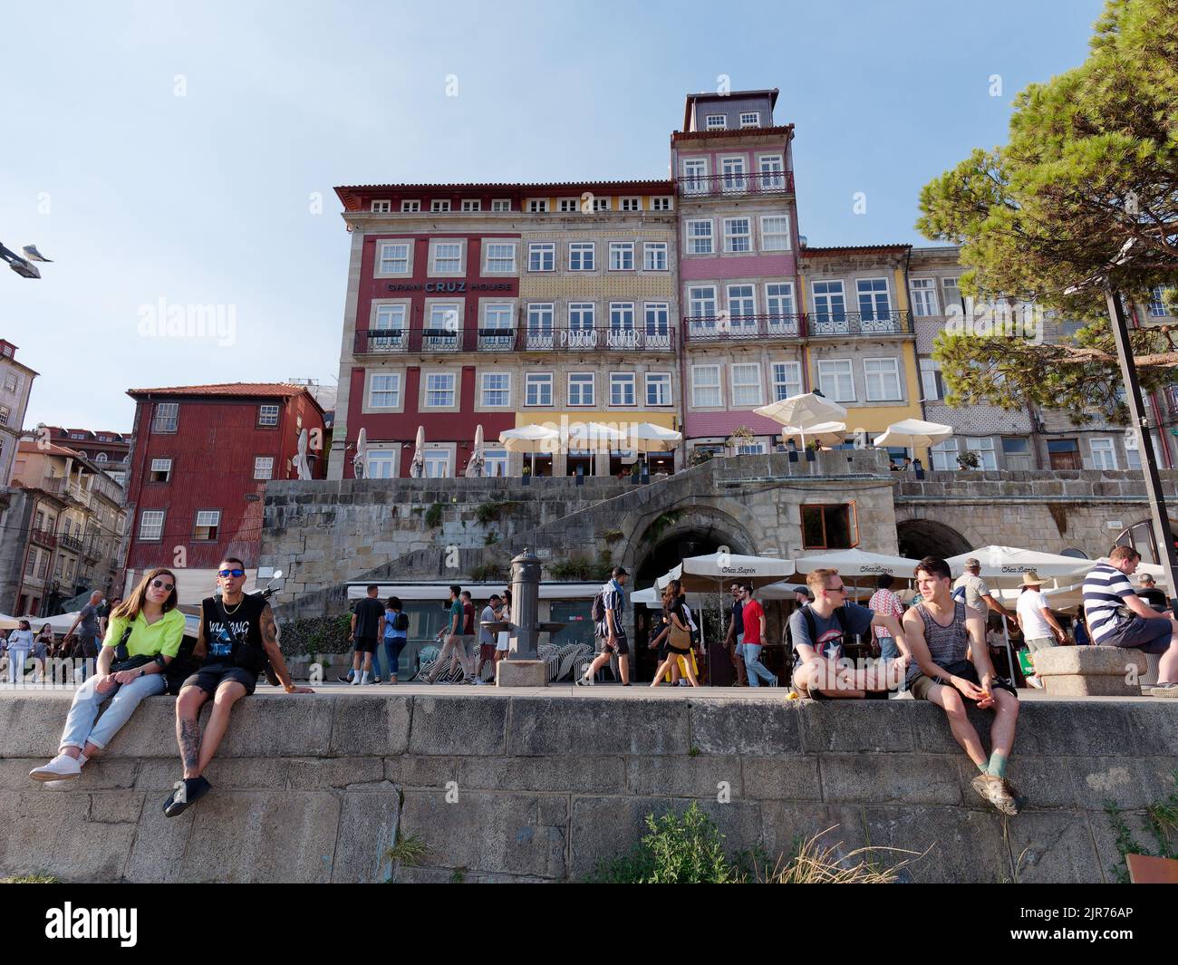 People walking along the riverside promenade in the Ribeira district of ...