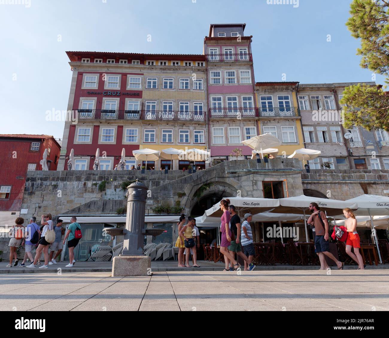 People walking along the riverside promenade in the Ribeira district of ...