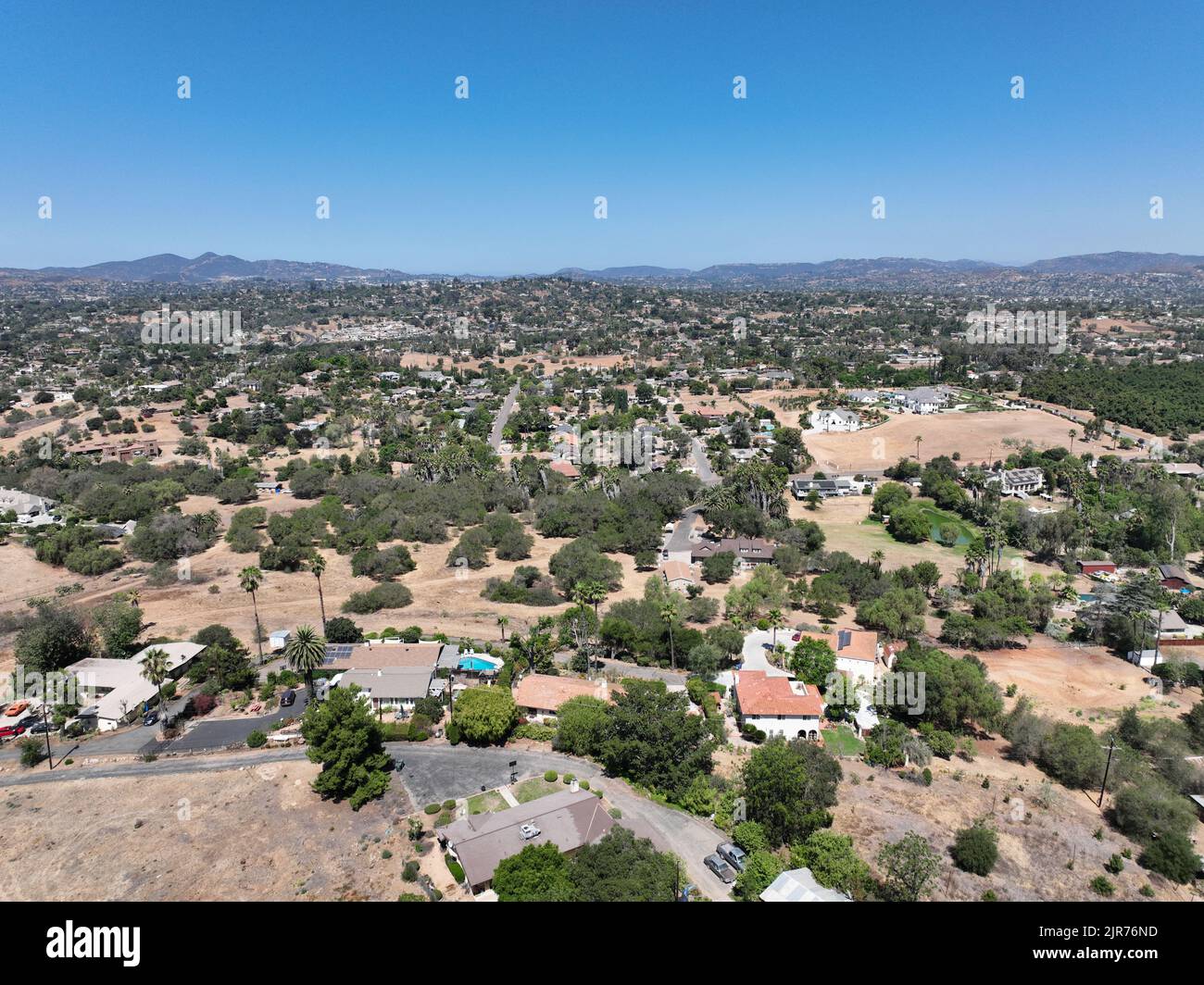 Aerial view of dry valley and land with houses and barn in Escondido ...