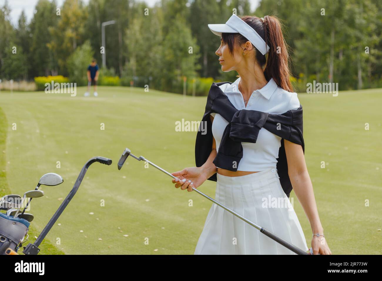 Smiling golfer woman with golf club outdoors on court. Active healthy ...